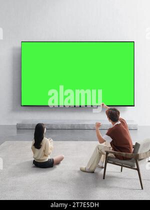 People are watching and enjoying next to the TV, monitor with green ...
