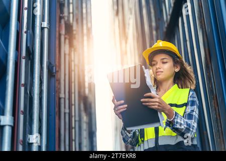 Engineer wears PPE checking container storage with cargo container ...