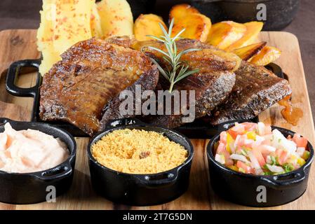 barbecued meat with cassava fried banana rice beans and herb sauce ...