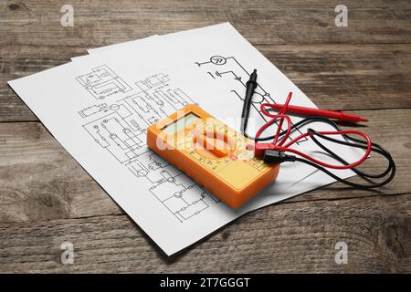 Wiring diagrams and digital multimeter on wooden table, flat lay Stock ...