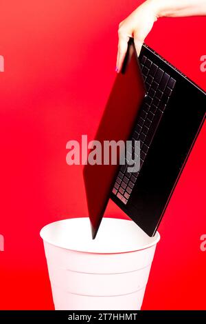 Black laptop in a trash bin on a red background isolated Stock Photo ...