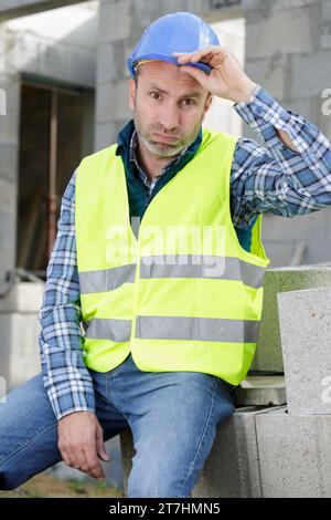 Disappointed construction worker with yellow hard hat Stock Photo - Alamy