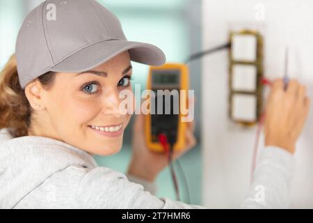female electrician using multimeter on old electric meter Stock Photo ...
