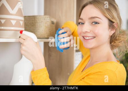 Lady dusting shop shelf Stock Photo - Alamy