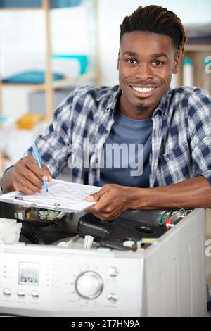 man repairs a washing machine Stock Photo - Alamy