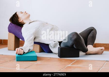 Woman doing restorative yoga supported butterfly pose with props Stock ...