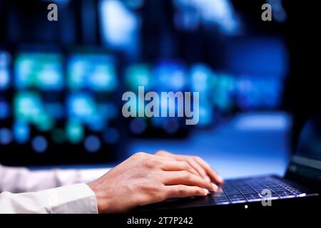 Admin using laptop to set up supercomputer hub infrastructure advanced ...