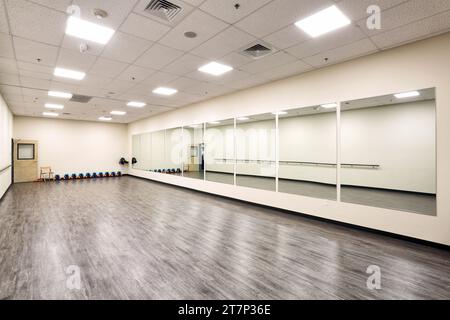 The interior of a modern dance studio with hard floors, and mirrors on ...