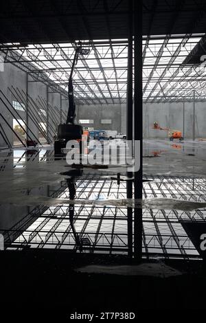 A welder welding steel roof trusses during the construction of a ...