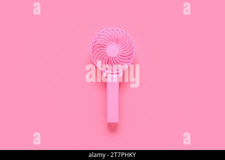 Modern manual fan on pink background Stock Photo - Alamy