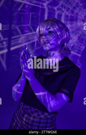 portrait of charming female cosplayer in blonde wig with hieroglyphs ...