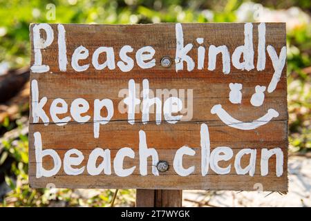 Sign saying "'Please kindly keep the beach clean"" and pile of ...