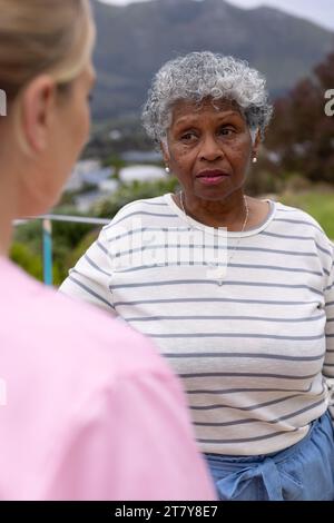Serious young African American female in denim outfit standing against ...