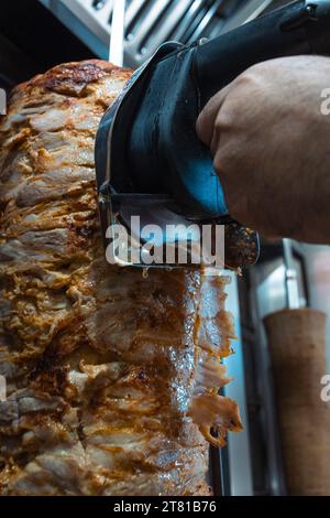 Chef uses slicer to cut kebab roll Stock Photo - Alamy