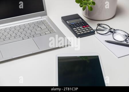 Flower in a pot, calculator, white alarm clock, multi-colored pieces of ...