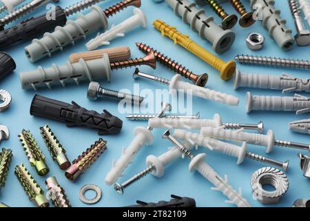 Many different fasteners and dowels on light blue background, above ...