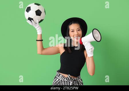 Female Asian football fan with megaphone on magenta background Stock ...