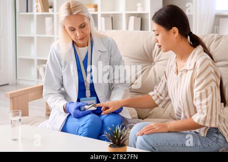 Asian women doctor working from home using laptop computer writing ...