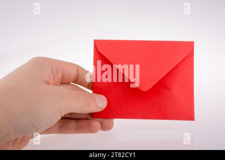 hand holding a red envelope on a white background Stock Photo - Alamy