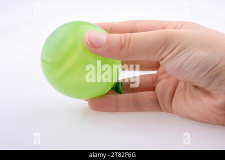 Hand holding a Colorful small balloon with colorful balloons on the ...