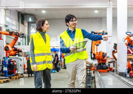 Japanese chief engineer explaining and pointing robotic welding process ...
