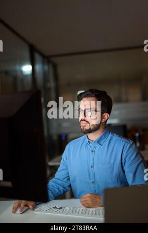 Young financial manager working late at night in office Stock Photo - Alamy