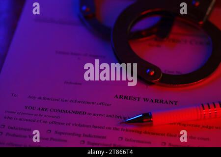 District Court Arrest Warrant court papers with handcuffs and blue pen ...