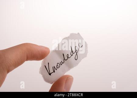 Knowledge written torn paper on a white background Stock Photo - Alamy