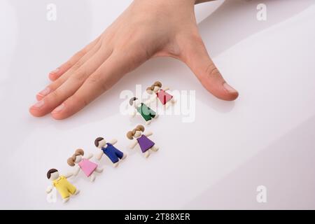 Hand near colorful dressed children figures on a white background Stock ...
