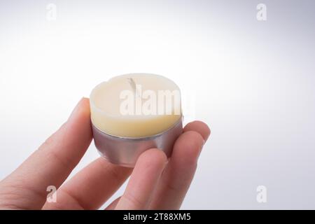 White color small Candle in hand on a white background Stock Photo - Alamy