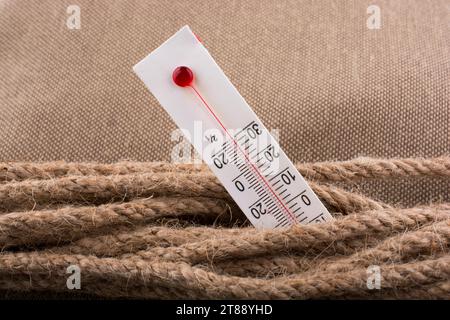 Thermometer placed on a brown rope on a fabric background Stock Photo ...
