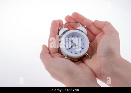 Alarm clock in hand on a white background Stock Photo - Alamy