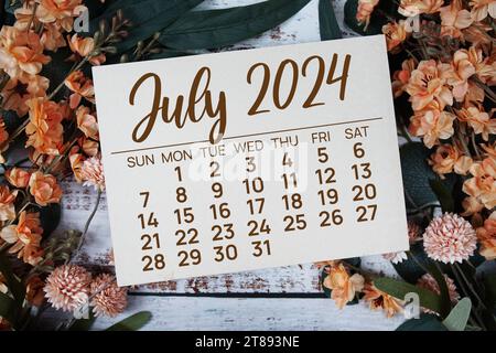 July 2024 monthly calendar with flower bouquet decoration on wooden ...