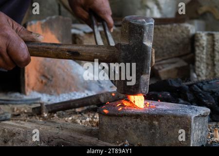 Nepalese blacksmith hammers on red-hot steel to make agricultural tools ...