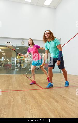 People playing squash enjoying recreational pursuit at indoor training ...