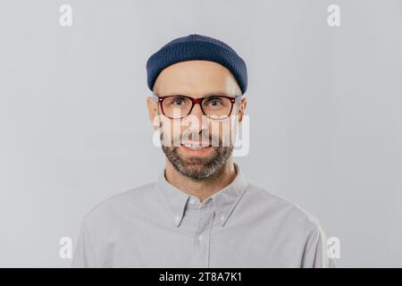 Headshot of handsome unshaven man wears transparent glasses, headgear ...