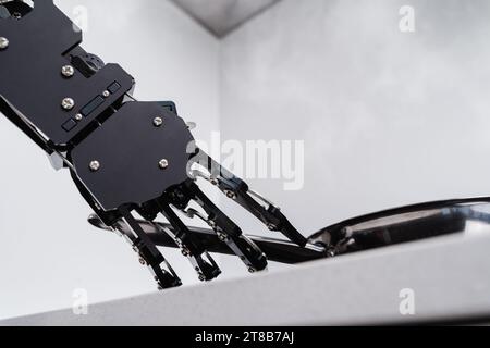 Real robot hand and frying pan on electric stove. Concept of robotic ...