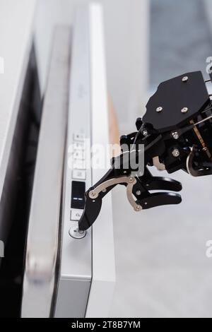Real robot hand pushing button on dishwasher. Concept of Artificial ...