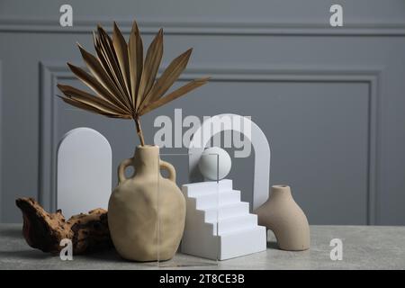 Clay flagon and other decorative elements on grey textured table, space ...