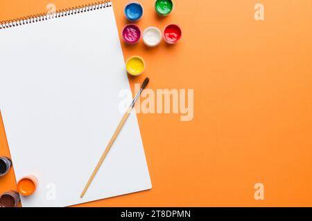 Album pages and paints, pencils, brush on a colored background. Top ...