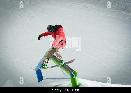 One male snowboarder jibbing a terrain park at a ski resort Stock Photo ...