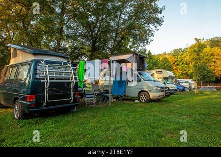 camping life with motorhomes and cars and tents in the early morning ...