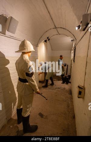 A sergeant is supervising the soldiers moving the shell rounds in an ...