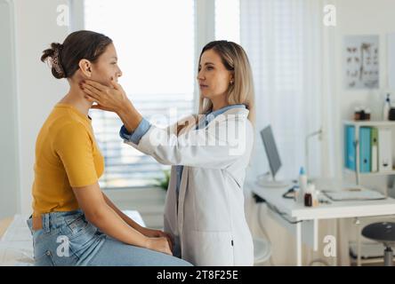 Doctor examining lymp nodes on neck of the young girl. Palpation of ...
