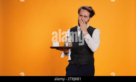 Overworked butler stretching in studio, feeling exhausted after long ...