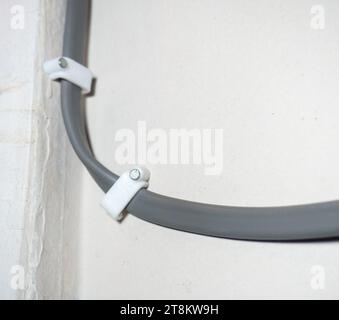 Fastening the wire to the wall. Ceiling mounting. Electric cord in the ...