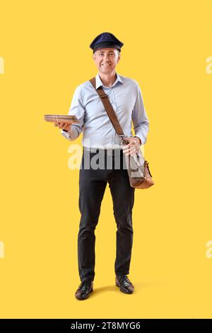 Mature postman with letters on yellow background Stock Photo - Alamy