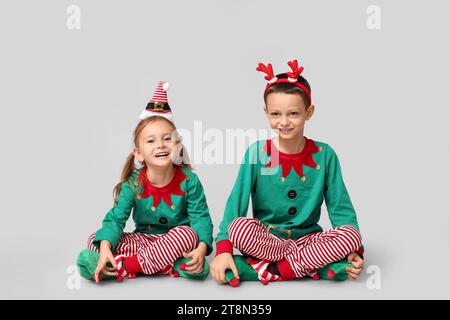 Cute little children dressed as elves on grey background Stock Photo ...