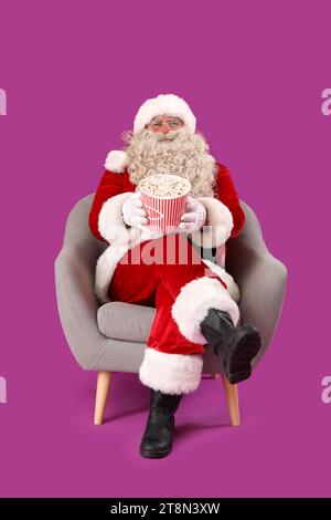 Santa Claus with tasty popcorn on red background Stock Photo - Alamy