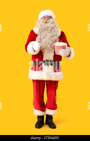 Santa Claus with tasty popcorn showing thumb-up on white background ...